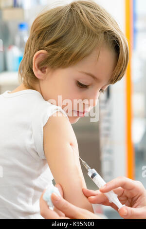 Cute boy being injected at clinic Stock Photo - Alamy