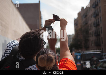 Solar eclipse seen from the streets of Queens in New York Featuring ...