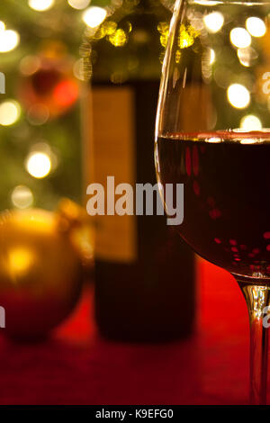 Christmas tree with red wine bottle on red wall background. New Year or ...