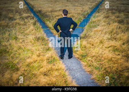 Man standing at a crossroads Stock Photo - Alamy