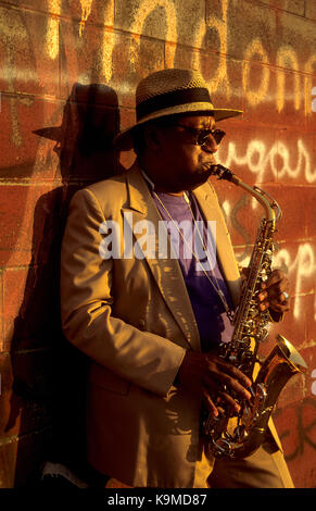 A Jazz Musician Playing on a City Street in Front of a Graffiti Covered ...