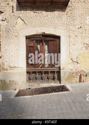 Painted wall of an old smashed up mini and a sign indicating No Parking ...