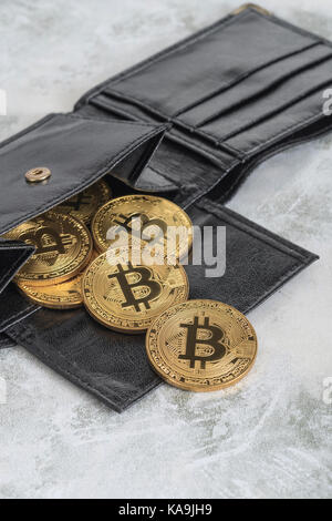 Gold Bitcoins spilling from black billfold wallet. For Bitcoin wallet ...