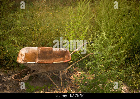 old broken and rusty wheelbarrow abandoned on a lawn Stock Photo - Alamy
