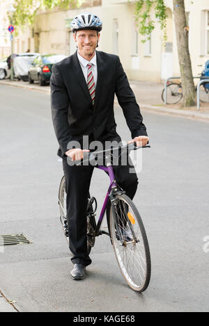 A caucasian businessman riding a bicycle to work, can be used for gas ...