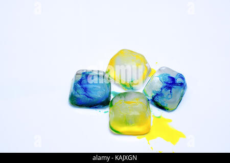 Ice cubes with food colouring on a white background Stock Photo - Alamy
