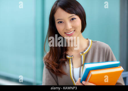 one pretty Chinese asian college student smile at camera in campus ...