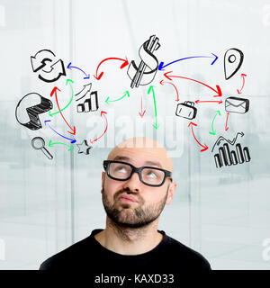 Portrait view of an attractive dubious business man with business icons ...