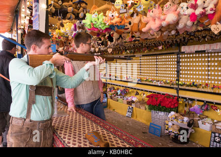 Man in traditional lederhosen playing carnival game during Oktoberfest ...