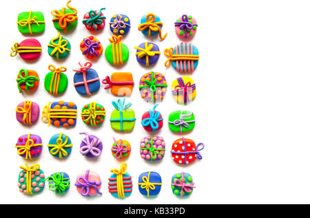 Many small gifts from plasticine. Yellow background Stock Photo - Alamy