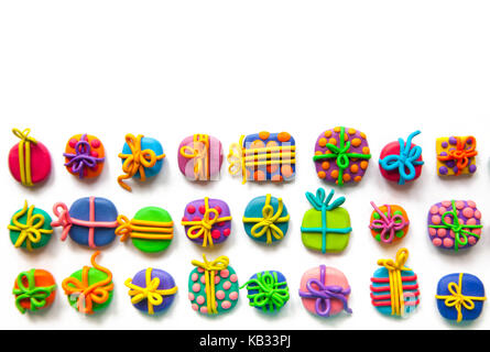 Many small gifts from plasticine. Yellow background Stock Photo - Alamy