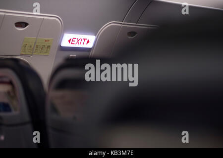 Aircraft emergency exit sign and door on board passenger airplane Stock ...