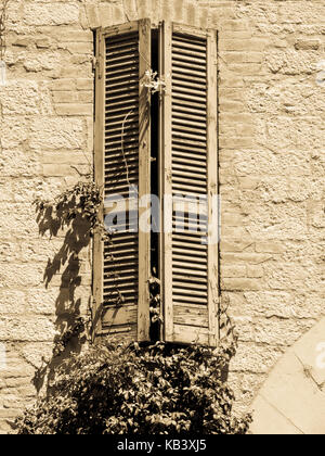 Italian style wooden window with closed shutter blinds on brick wall ...