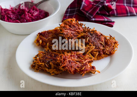 beetroot and potato rosti on white plate and table Stock Photo - Alamy