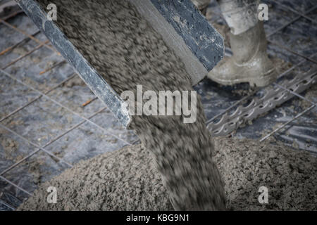 Concrete buggy is on construction site, moving wet cement across gravel ...
