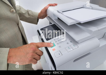 Midsection Side View Of Businessman Pressing Printer's Button In Office ...