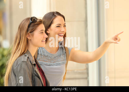 Two happy shoppers watching a storefront on the street Stock Photo - Alamy