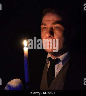 Butler with candle Stock Photo - Alamy
