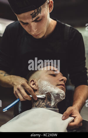 barber shaving a client with a razor Stock Photo - Alamy