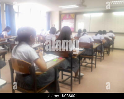 Blur school or university students writing answer doing exam in ...