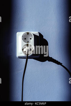 Electric plug inserted into an electrical outlet, white background ...