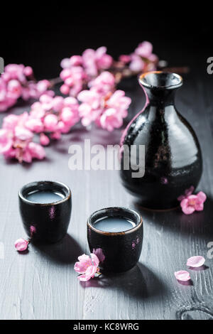 Traditional Japanese sake with blooming pink flowers. Method of serving ...