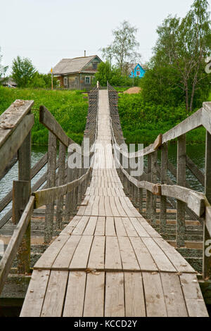 Old wooden suspension bridge across small river in Upper Modi Khola ...