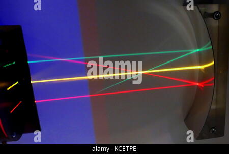 Three parallel beams of light are reflected off a mirrored surface ...
