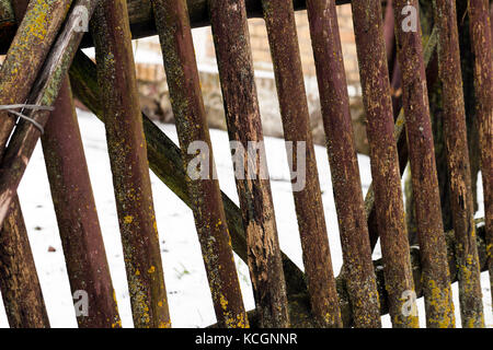 an old destroyed wooden fence in the countryside. Part of the fence is ...