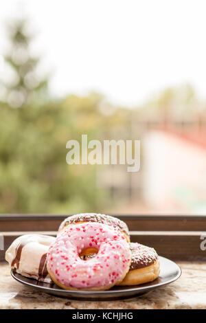 Plate with donuts next to window Stock Photo - Alamy