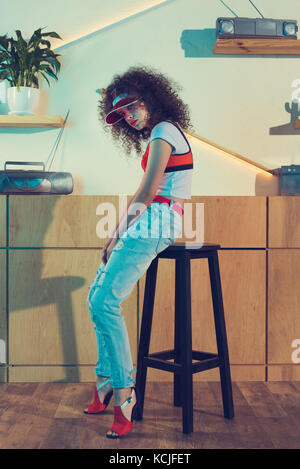Sexy fashionista sitting on high bar stool Stock Photo - Alamy