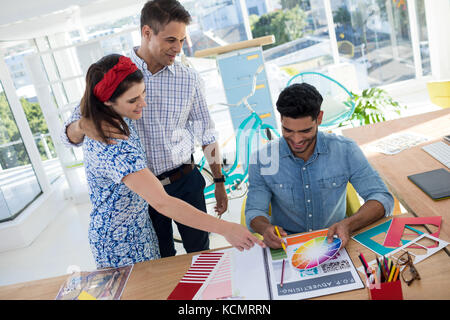 Team of graphic designers discussing over digital tablet in office ...