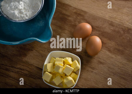 Flour in stainer with eggs and cheese on wooden table Stock Photo - Alamy