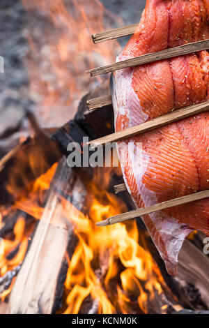 Salmon cooked first nation style over a fire, drips into the coals ...