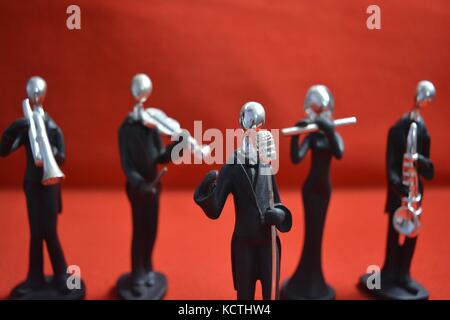 Toy man with microphone and musicians on the red background Stock Photo ...