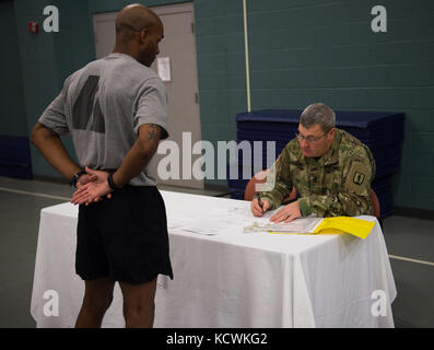 A Soldier fills out the Army Physical Fitness Test scorecard during day ...