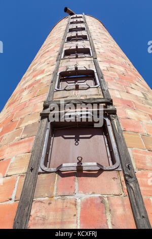 A historic grain silo with a red brick facade, weathered concrete ...