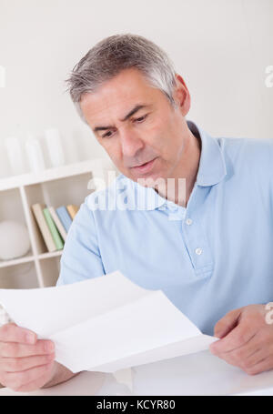 Horrified old man reading a document with an aghast expression Stock ...