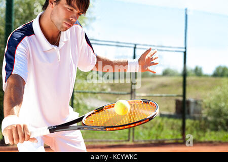 Portrait of a young man holding a tennis racket and a tennis ball Stock ...