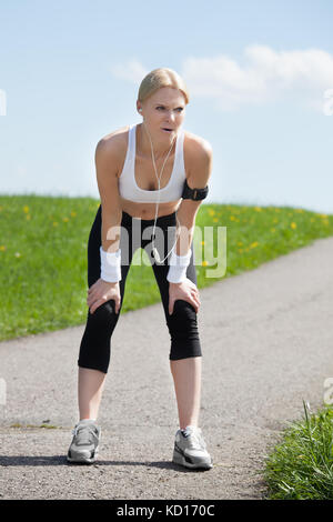 Tired attractive woman after jogging at the stadium Stock Photo - Alamy