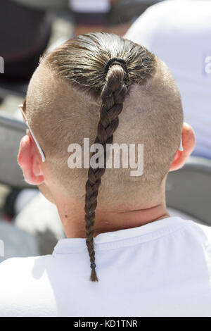Image from back of brunet in sunglasses washing mirror sitting in car ...