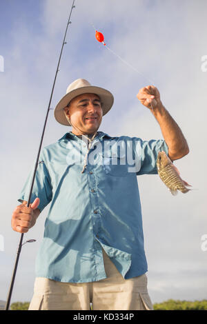 Low section of mature man fishing at lakeshore Stock Photo - Alamy