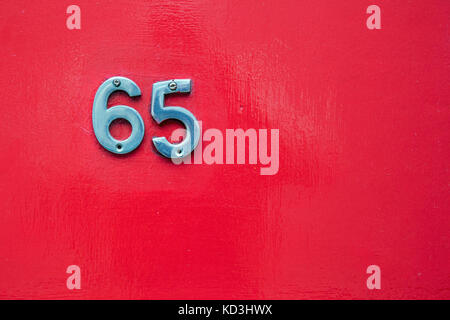 Number 65 in chrome against a red background Stock Photo - Alamy