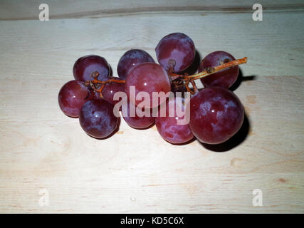 Red grape "cardinal" (vitis vinifera) on wooden table Stock Photo - Alamy