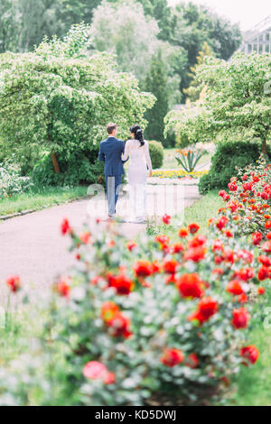 Portrait of a bride walking alone with bouquet in her hands in the park ...
