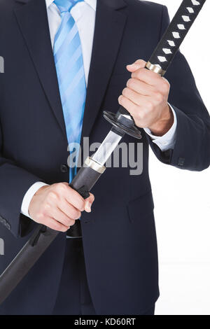 Close-up Of Businessman Removing Sword Over White Background Stock ...