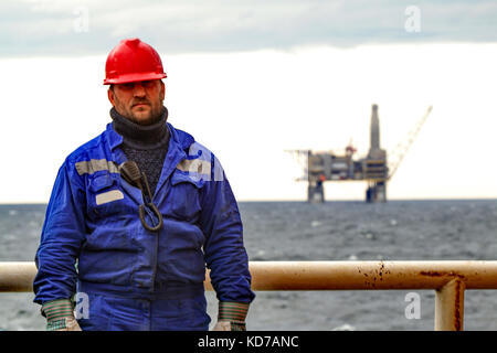 Oilman shift workers on the deck of the ship on the background offshore ...