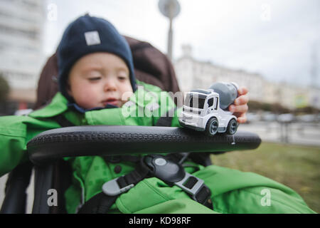 Adorable toddler playing with car toy standing by christmas tree at ...