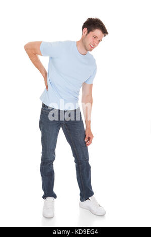 Young adult man standing over white brick wall smiling looking to the ...