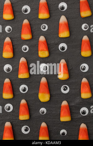 Halloween candy corn sweets and googly eyes background Stock Photo - Alamy